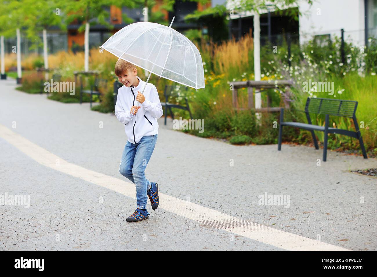 Boy holding an umbrella with raindrops. Happy little child boy having ...