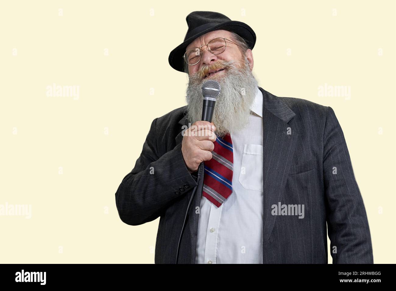 Portrait of aged bearded man singing with microphone. Isolated on ...