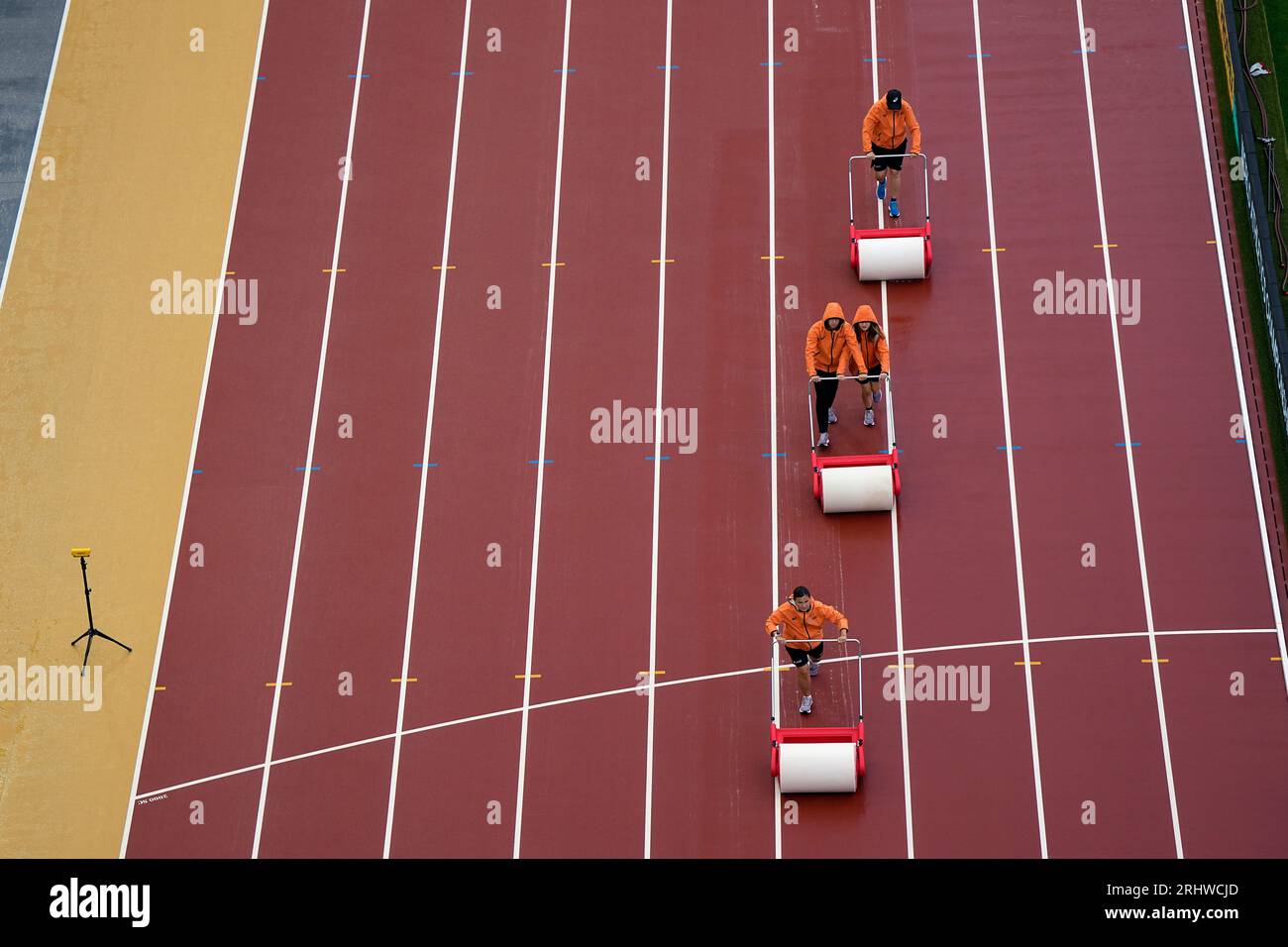 Workers dry the track after a rain storm during the World Athletics ...