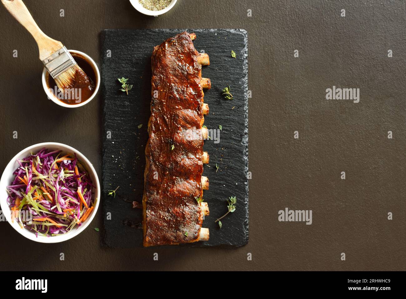 Bbq spare ribs on board over dark background with copy space. Top view ...