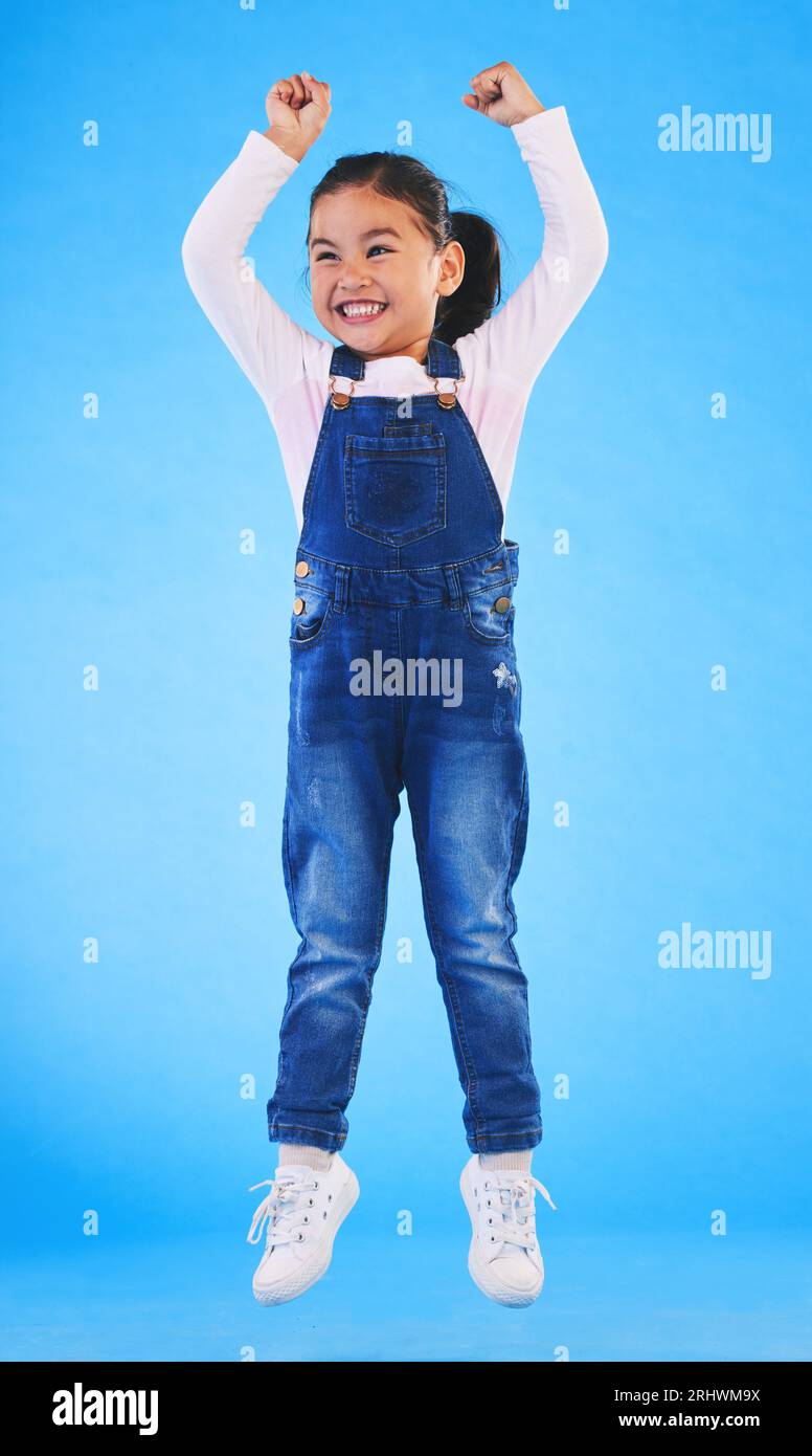 Girl child, jump and celebration in studio with fist in air for goal ...