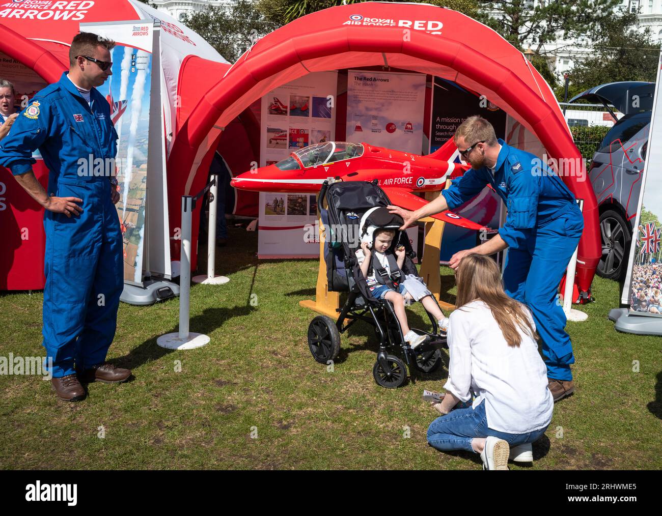 Eastbourne, UK. 19 Aug 2023. A young child in a pushcair tries on a RAF ...