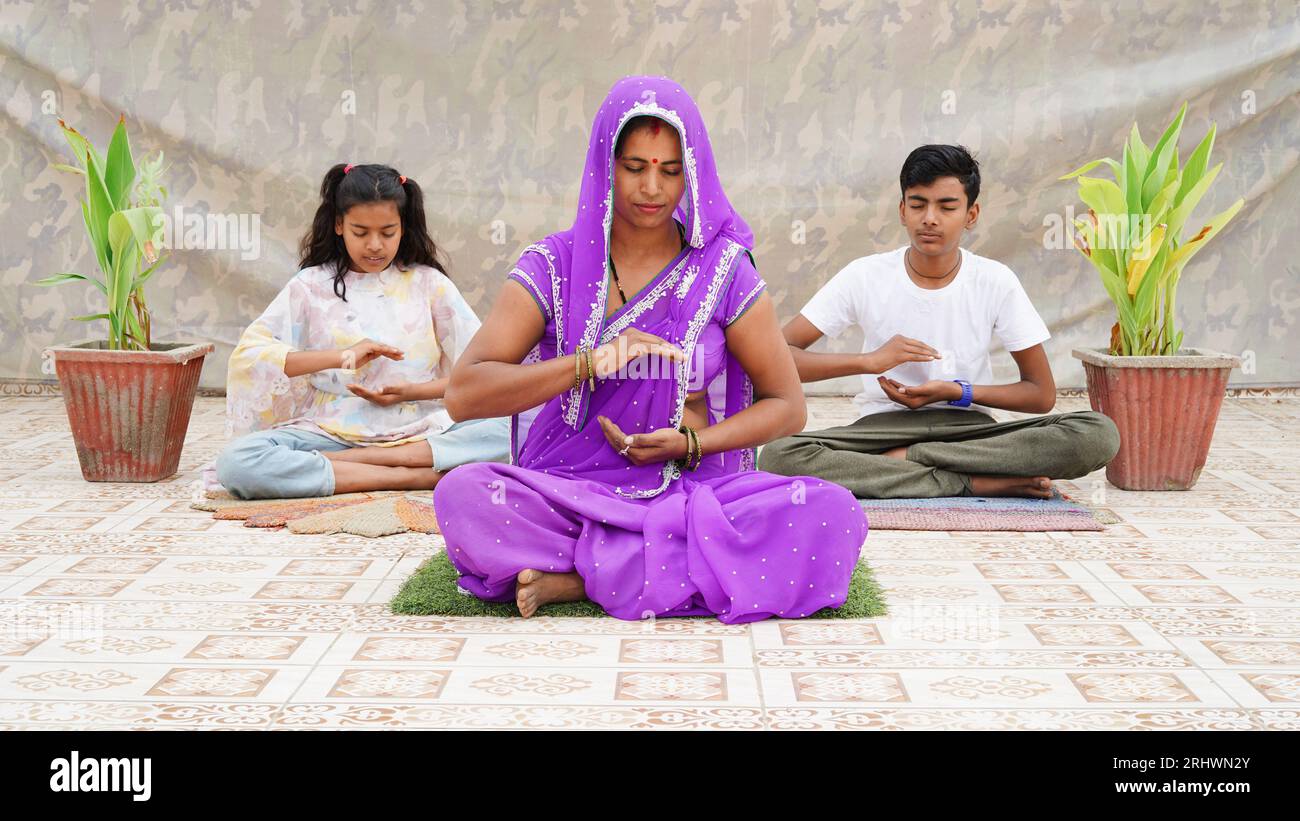 Indian mom make mudra gesture do meditation practice at home. Mom teach ...