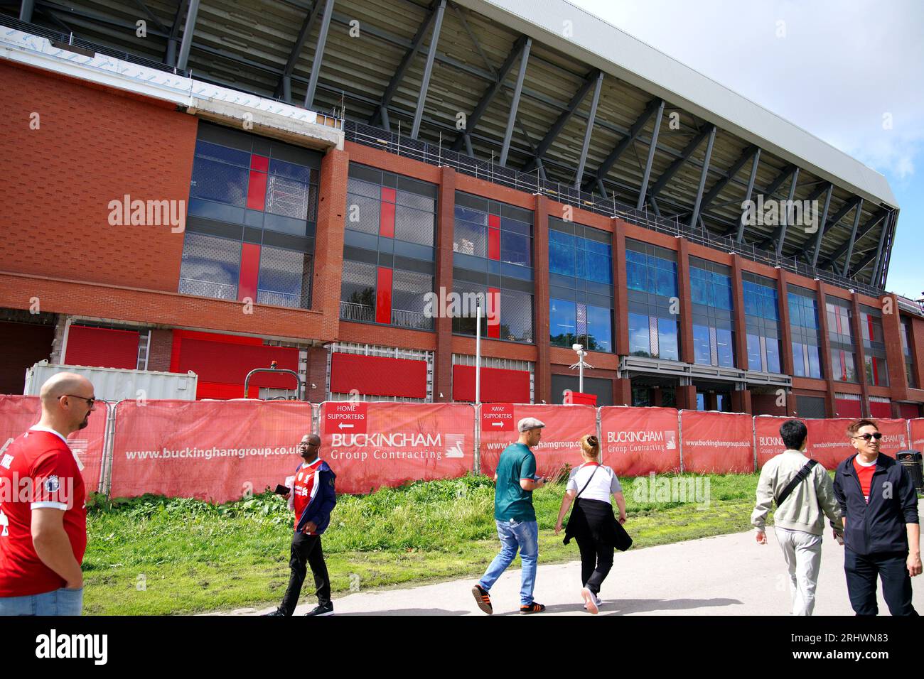 Liverpool fans walk past construction work on the new Anfield Stand ...