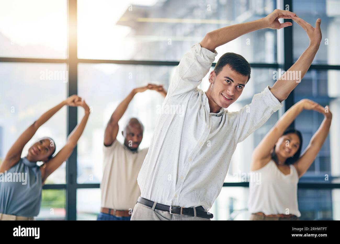 Team building, stretching and a team of business people in the office to workout for health or ...
