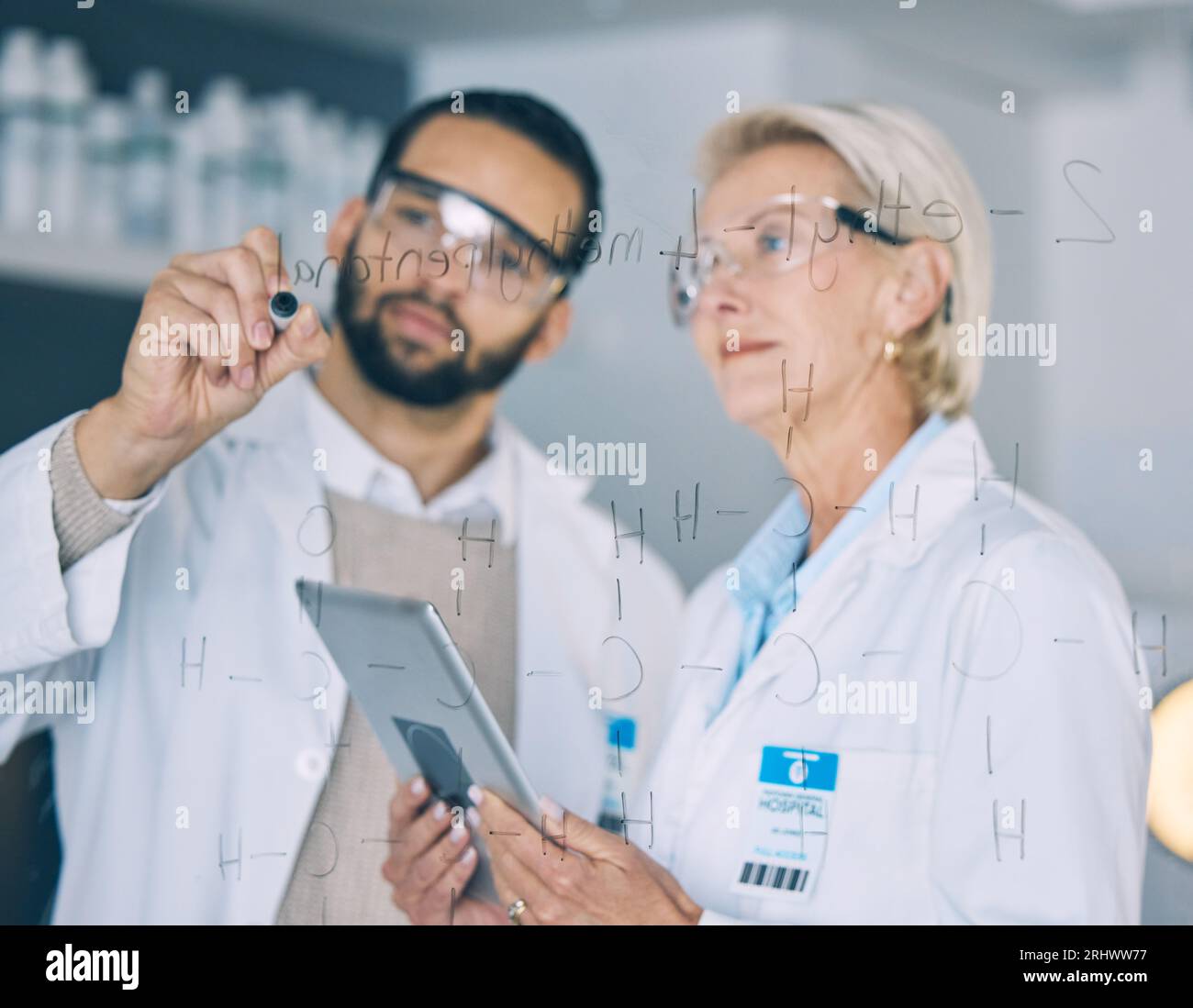 Tablet, science and a team planning while writing writing on glass in ...