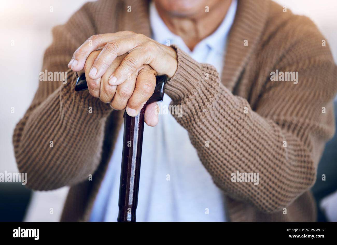 Hands, walking stick and senior person with a disability in nursing home for mobility support ...