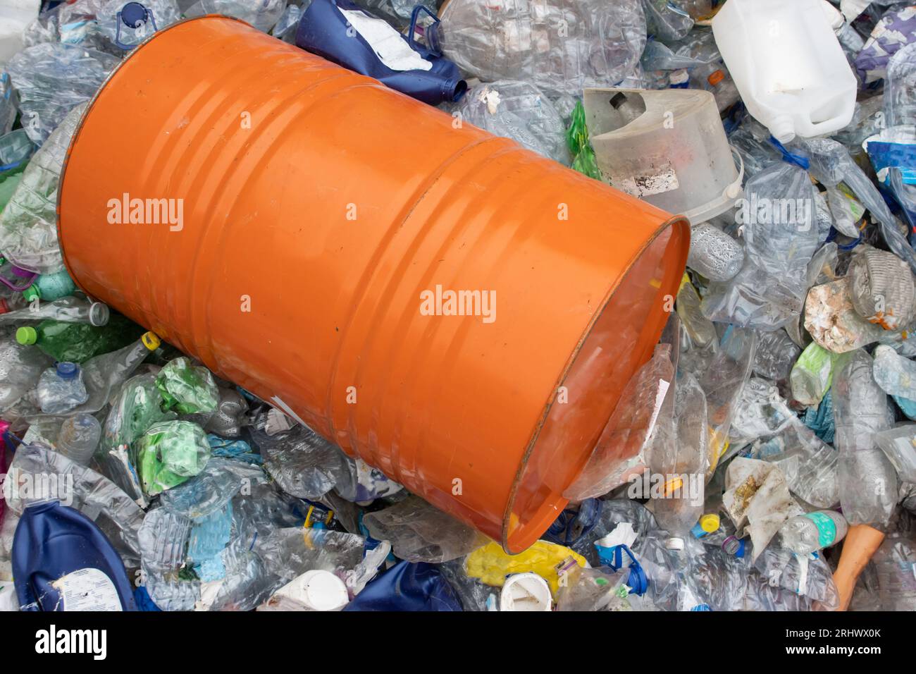 Orange barrel in a plastic garbage dump. Mid shot Stock Photo - Alamy