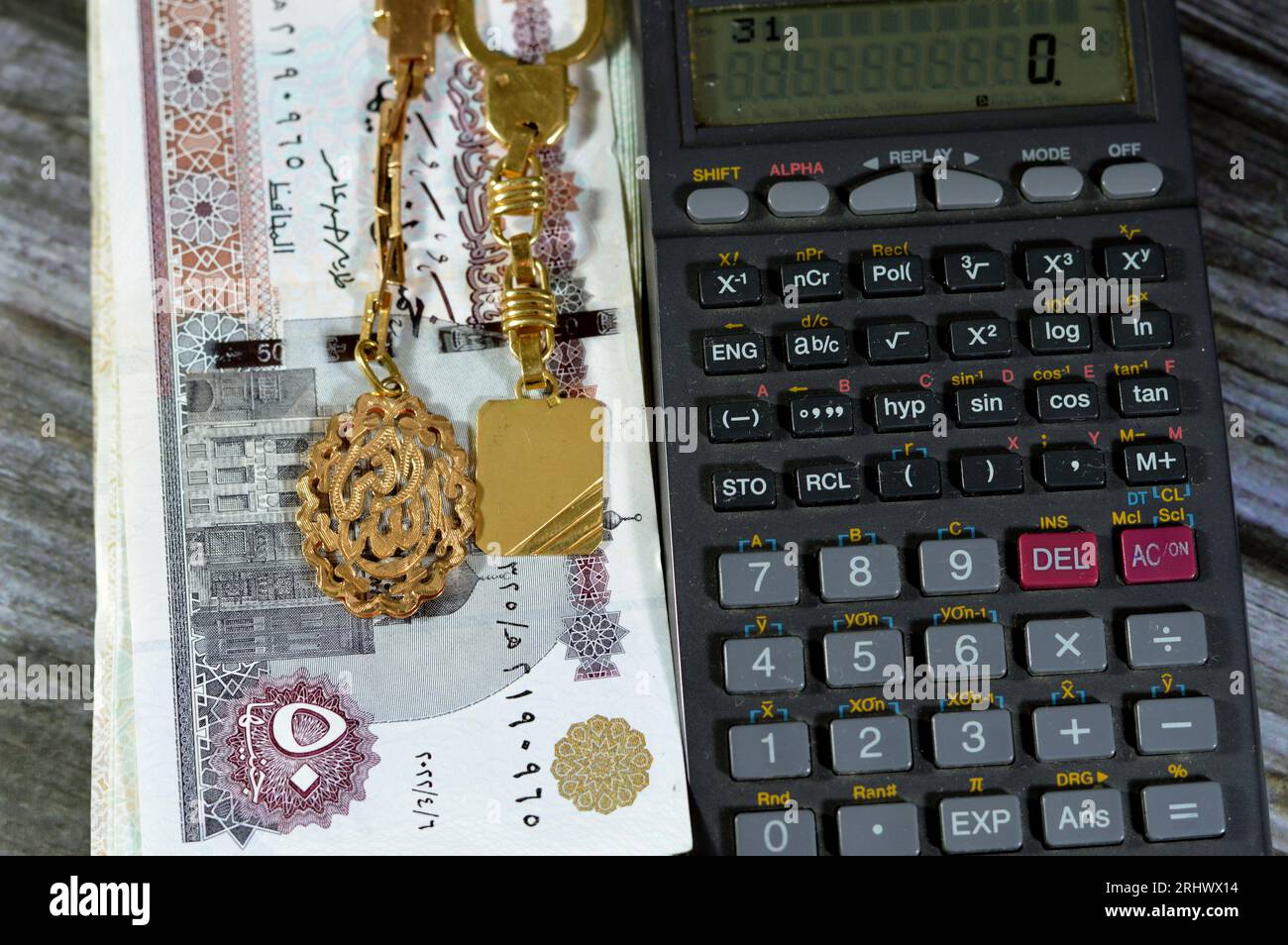 A calculator and golden keyring medals made of gold karat 18 with ...