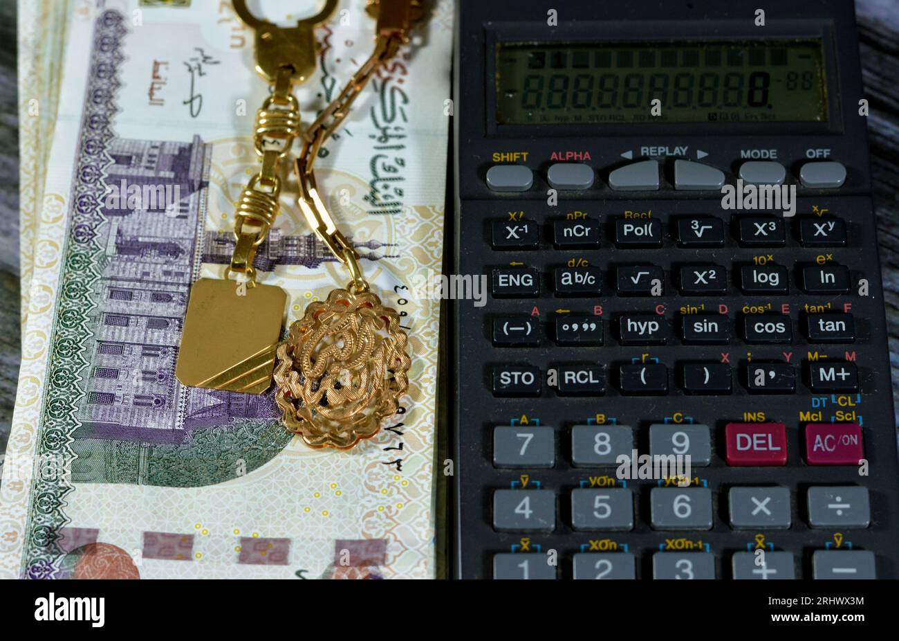 A calculator and golden keyring medals made of gold karat 18 with ...
