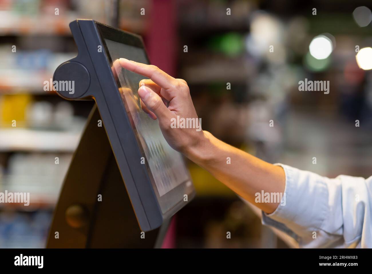 Close-up photo of a woman's hand in a supermarket inside using a self ...