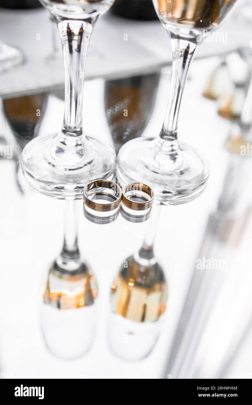Two golden wedding rings with champagne glasses on the table Stock ...