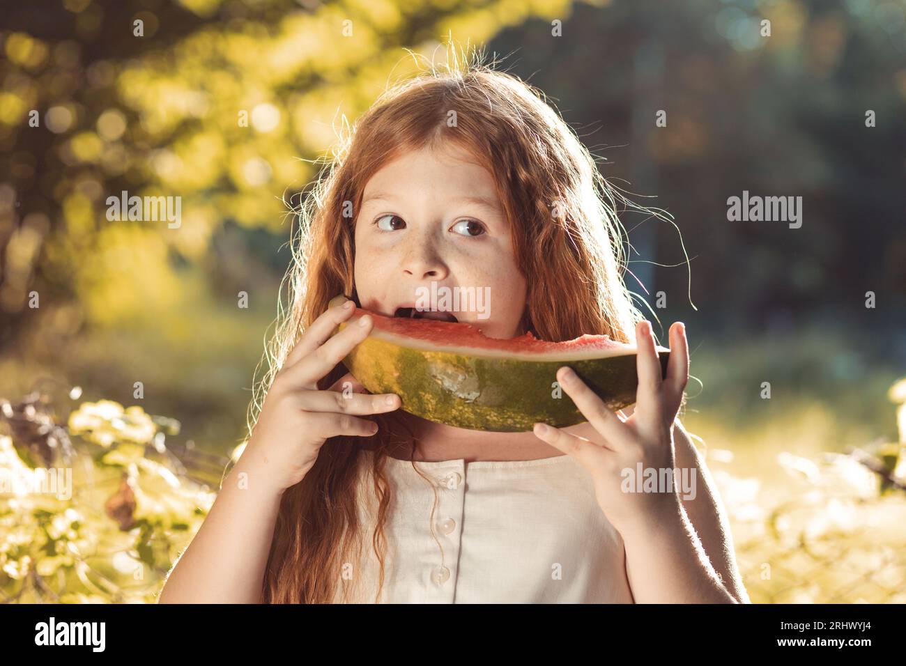 Cute little girl eating watermelon outdoors Stock Photo - Alamy