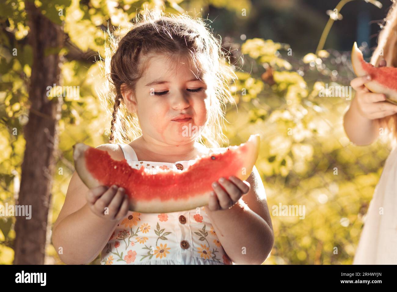 Cute little girl eating watermelon outdoors Stock Photo - Alamy
