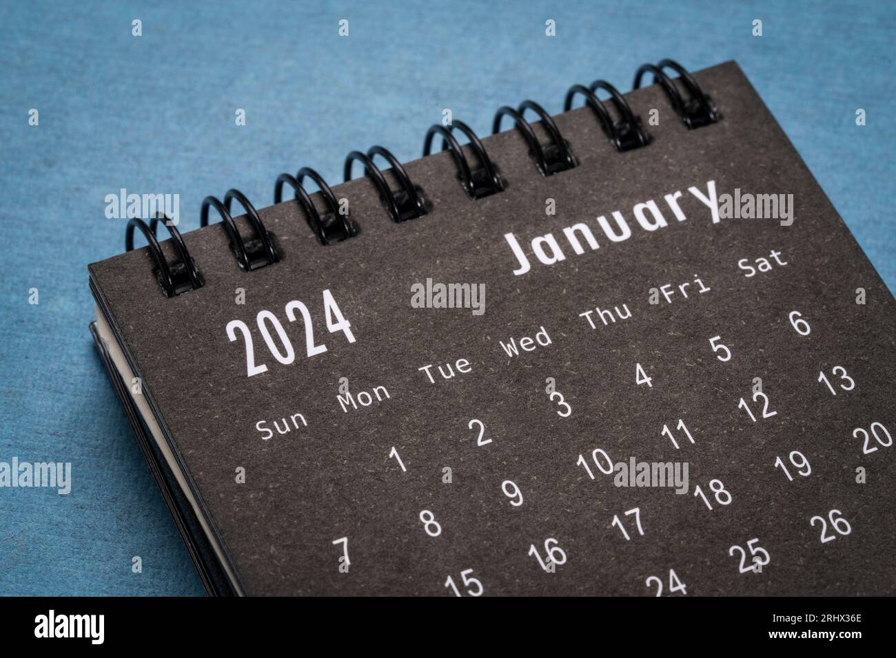 January 2024 - spiral desktop calendar against blue art paper, New Year ...