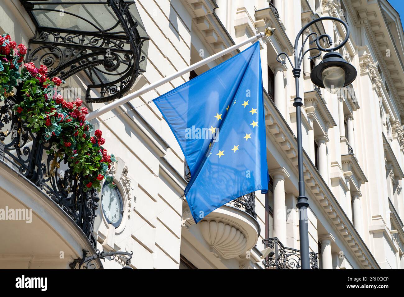 The blue EU flag flutters in the wind. Europe street house flagpole ...