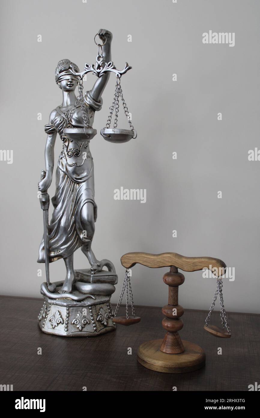 Statue of a woman symbolizing justice and law. wooden scales of justice ...