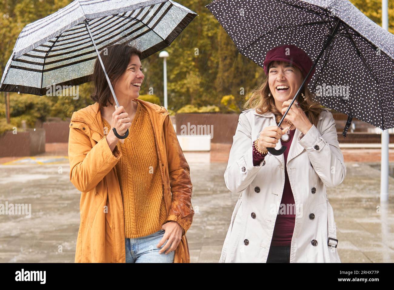 happy friends walking under the rain with umbrellas Stock Photo - Alamy