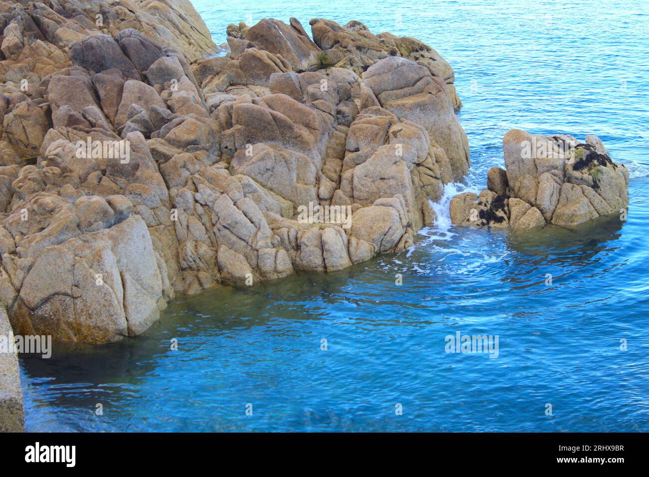 A photo of large rocks in a blue ocean Stock Photo - Alamy
