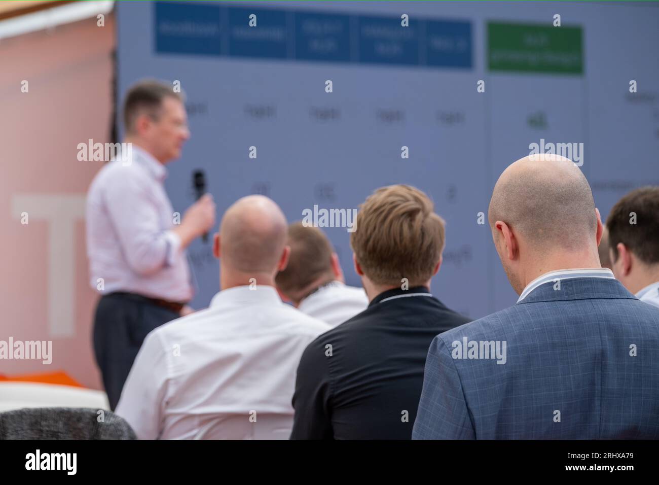 Back view of anonymous men in formal clothes gathering together in ...