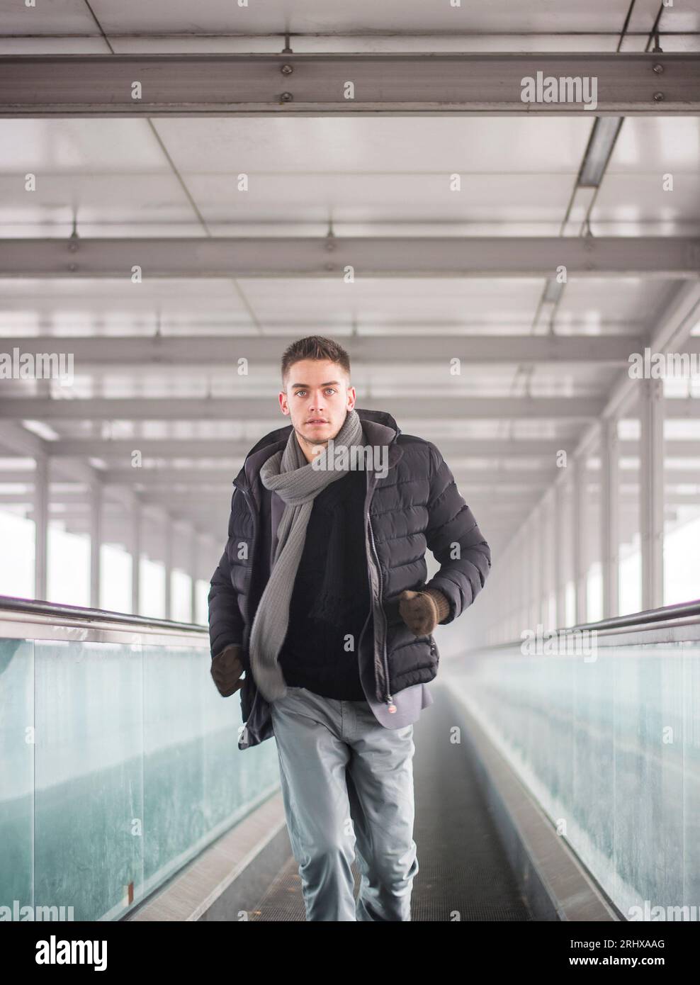 Photo of a man walking down a walkway in a building Stock Photo - Alamy