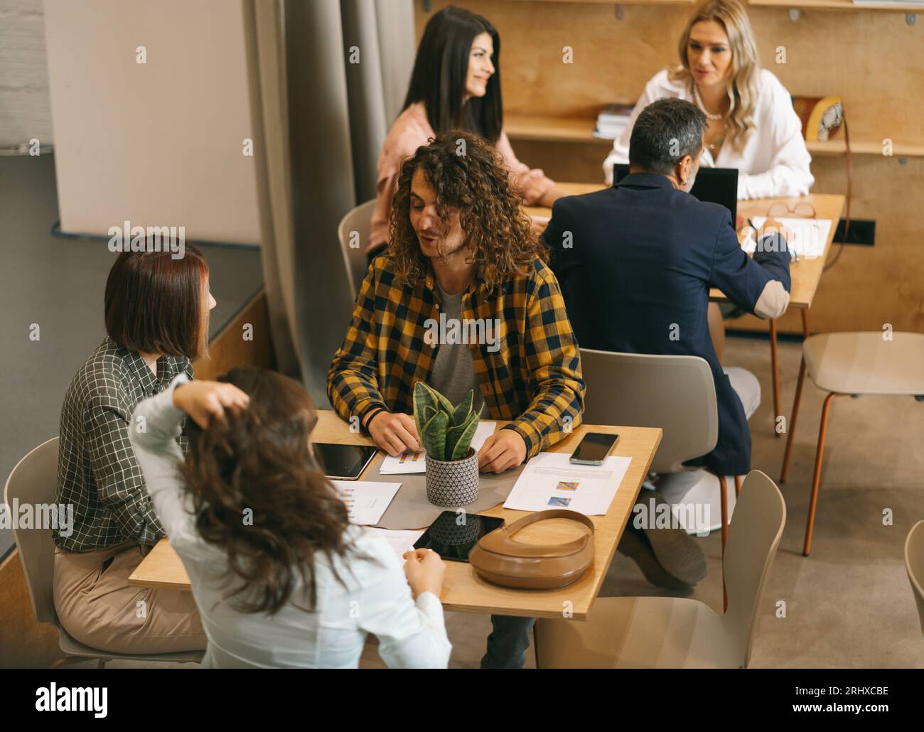 Young, long curly haired male person telling fun negotiation experience ...