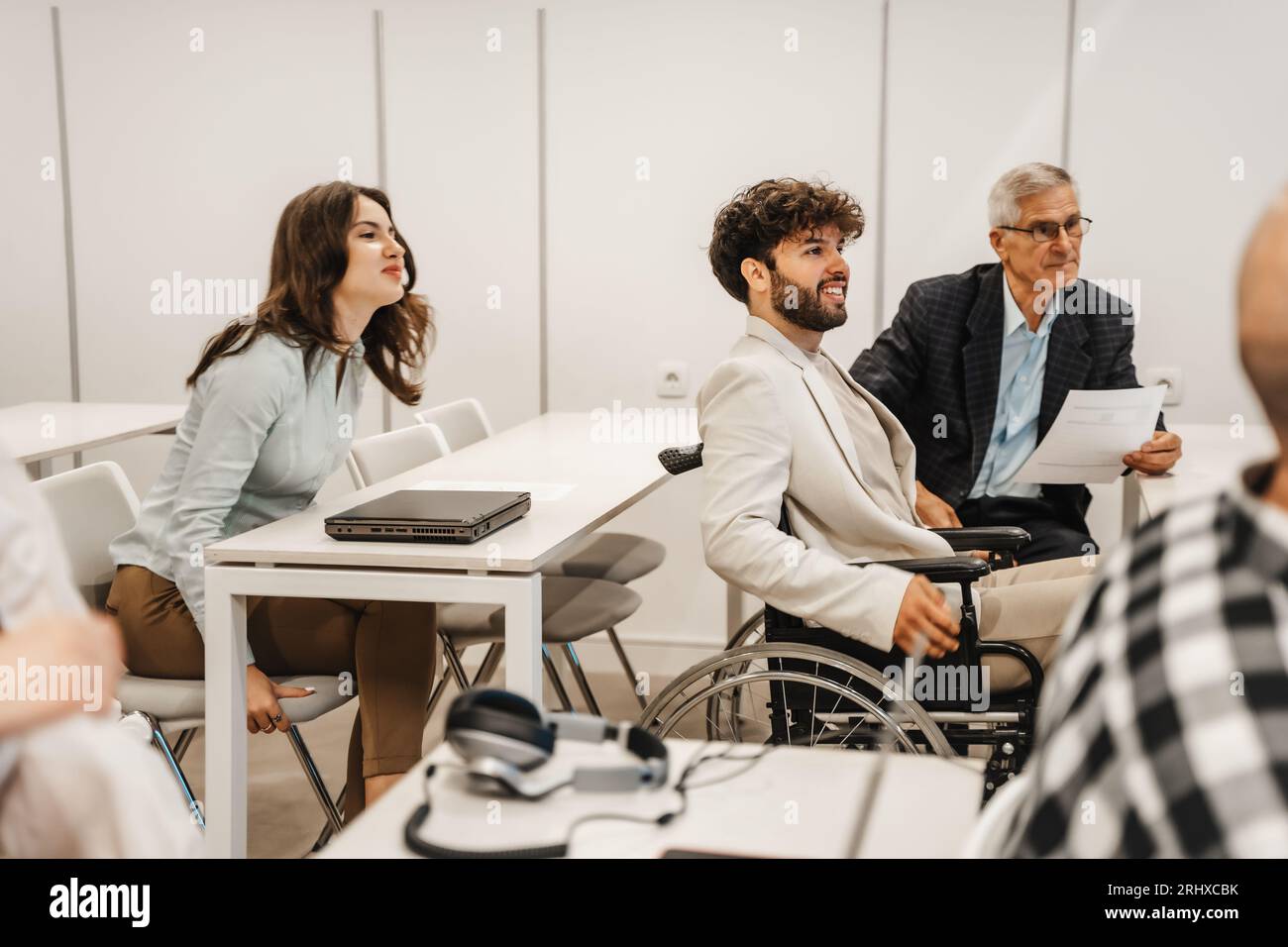 Handicapped male business person working with his colleagues at the ...