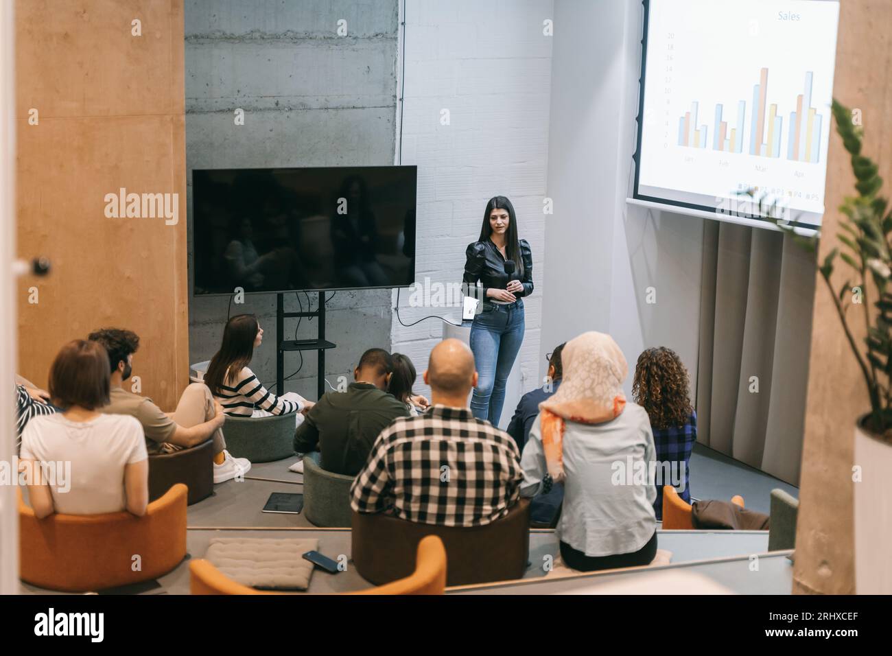 Young and beautiful business woman smiling and presenting a graph to a ...