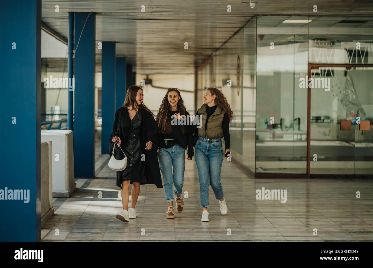 Beautiful young girls walking at the shopping mall and having fun. They ...