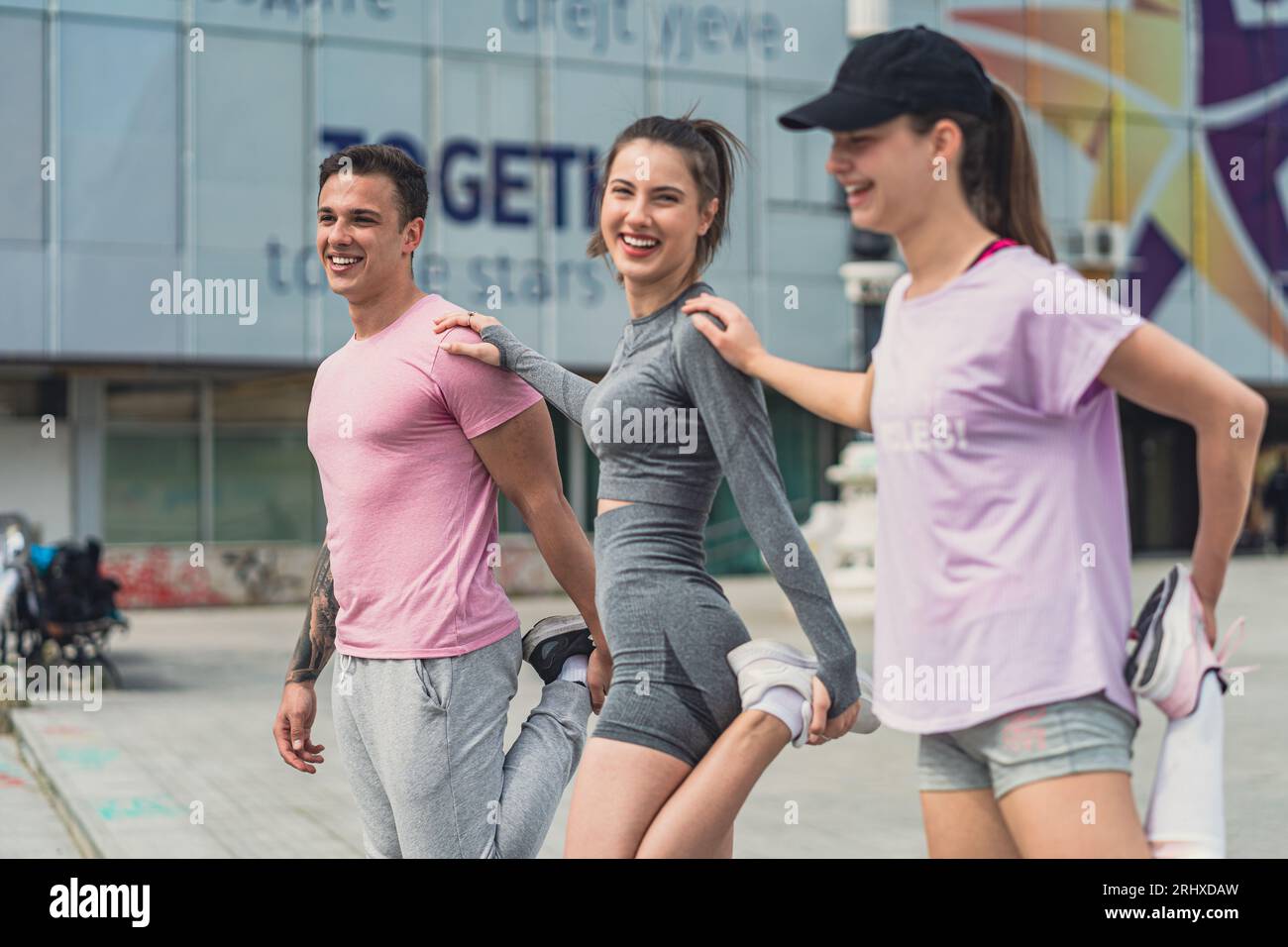 Three friends relying on each others shoulders while stretching their ...
