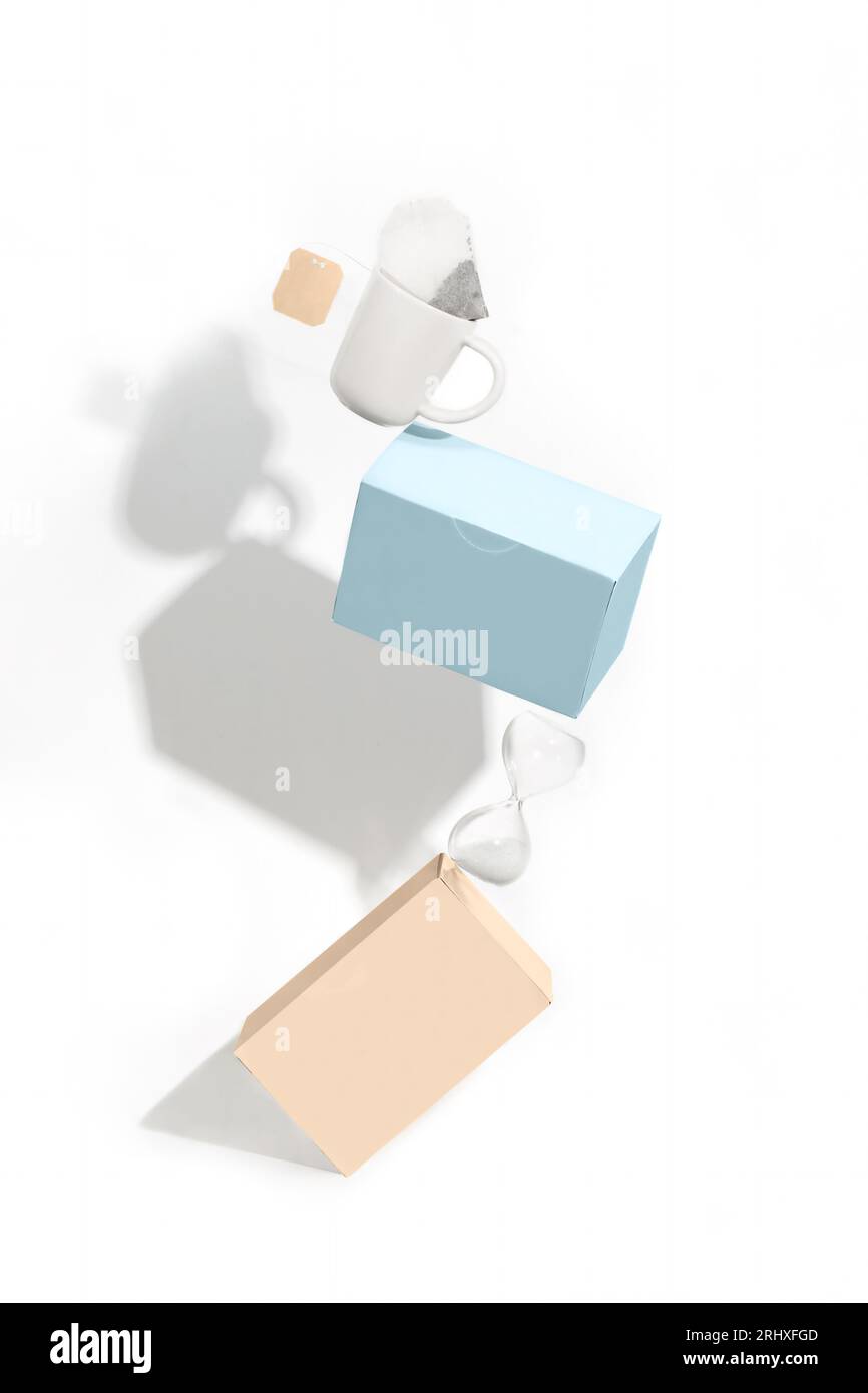 Balancing composition with boxes and a white tea cup against white ...