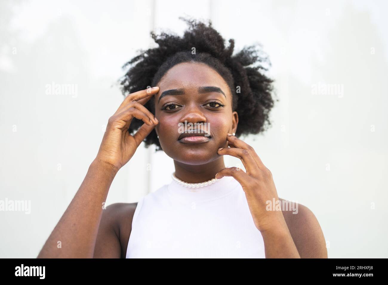 Portrait of young African American female in afro hairdo with white ...