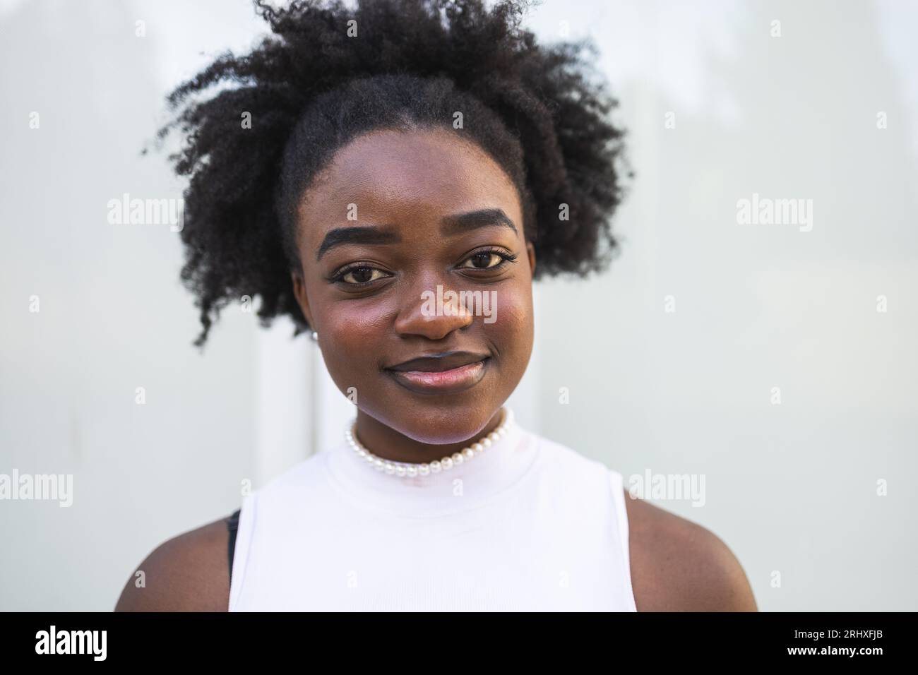 Portrait of positive young African American female in Afro hairdo with ...
