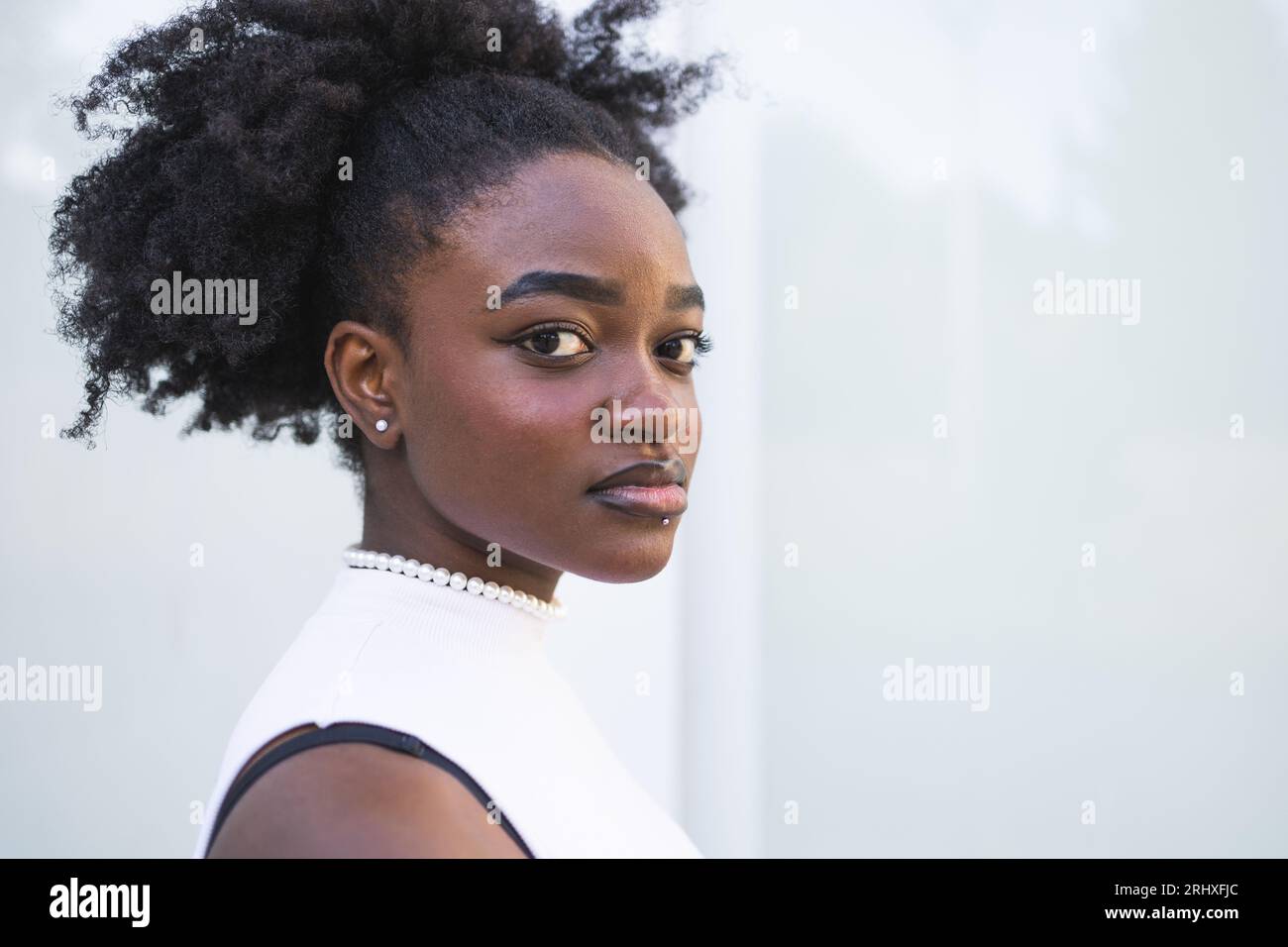 Side view portrait of young African American female in afro hairdo with ...
