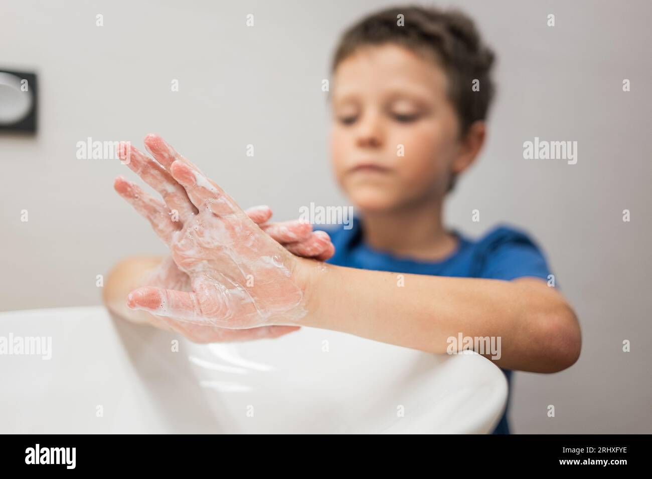 kid washing hands at sink with pouring soapy during daily hygiene ...