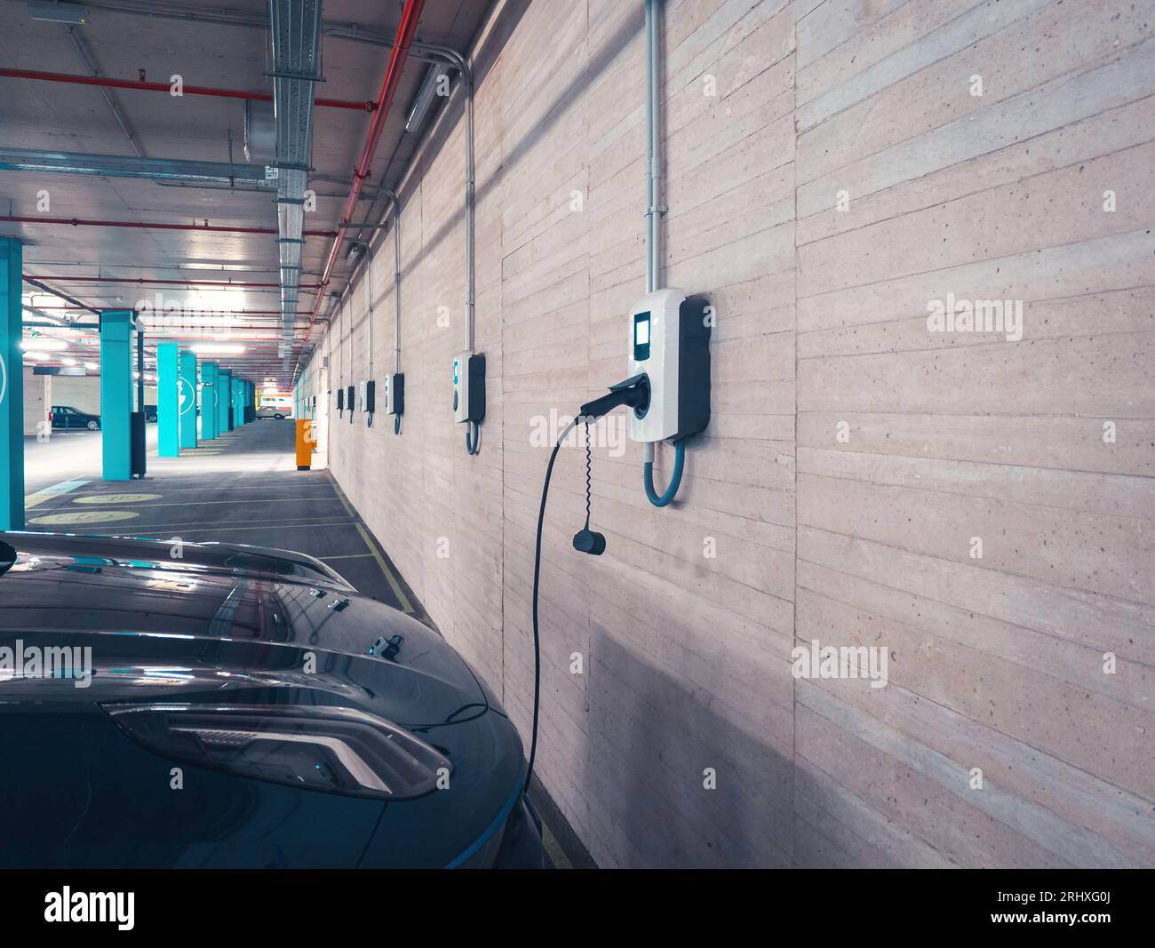 Modern hybrid vehicle connected to charging point for battery recharge ...