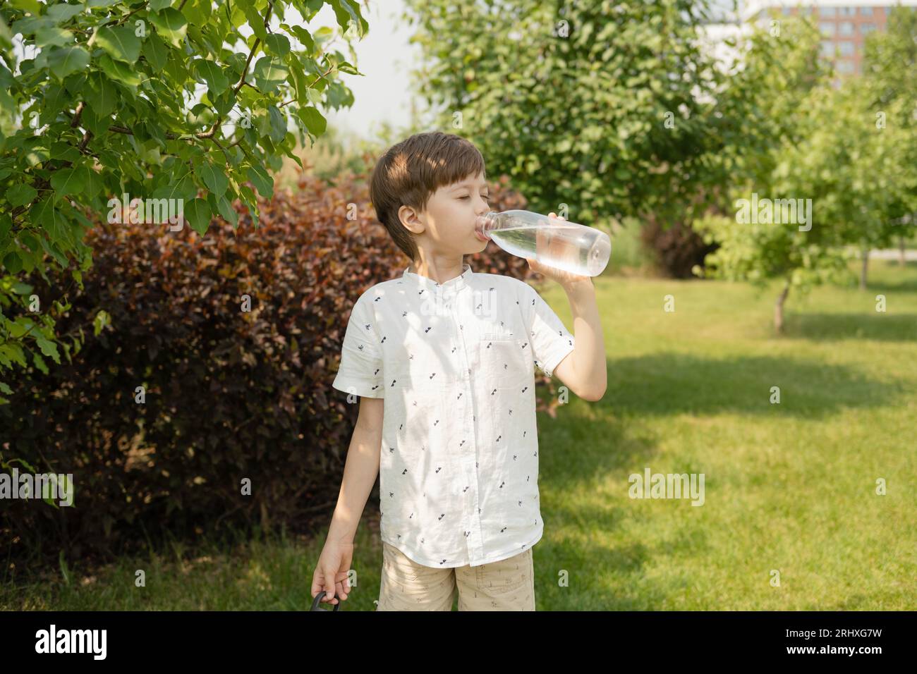 Cute Caucasian little thirsty boy with eyes closed drinking water from ...