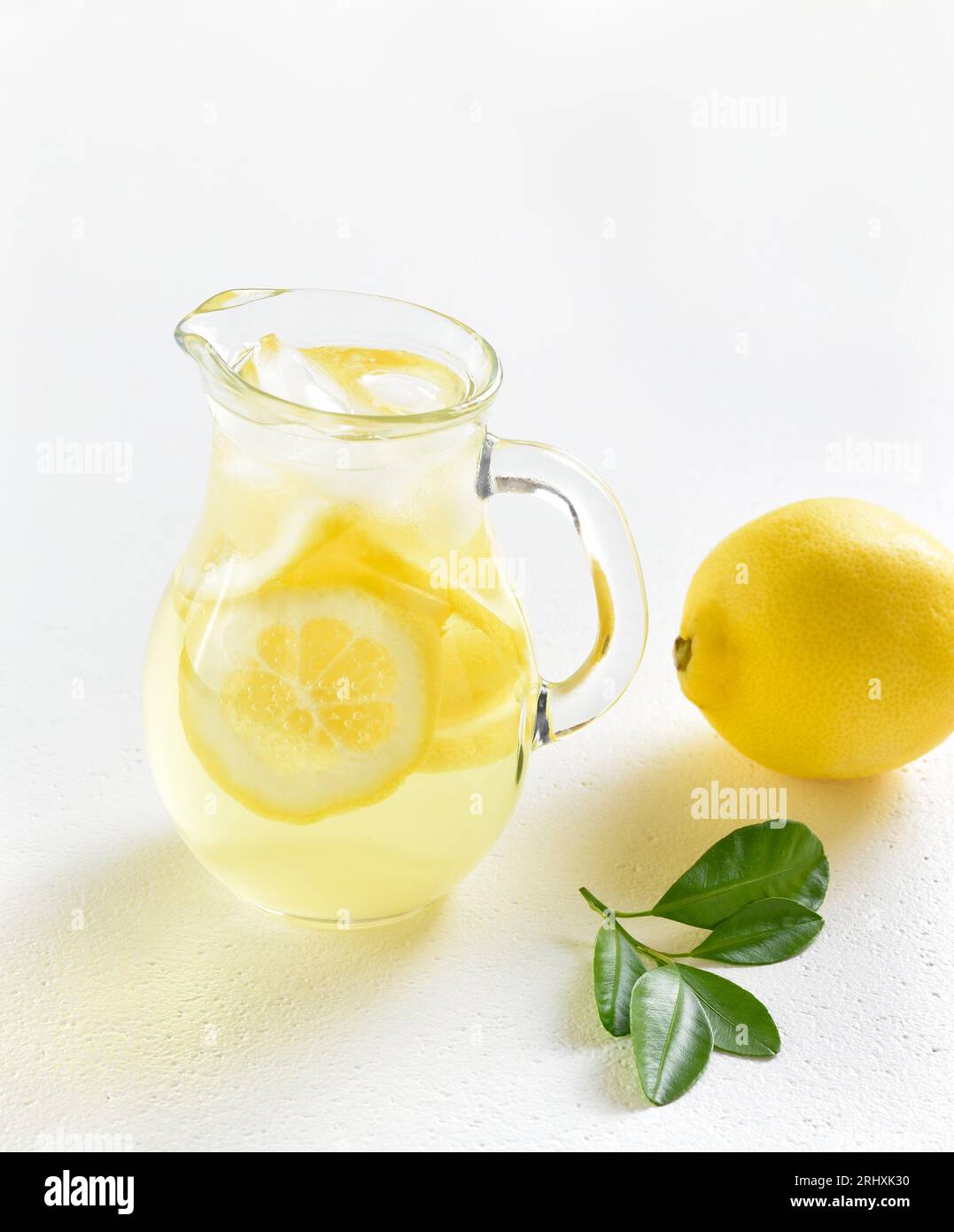 Lemon lemonade in glass pitcher on white background Stock Photo - Alamy
