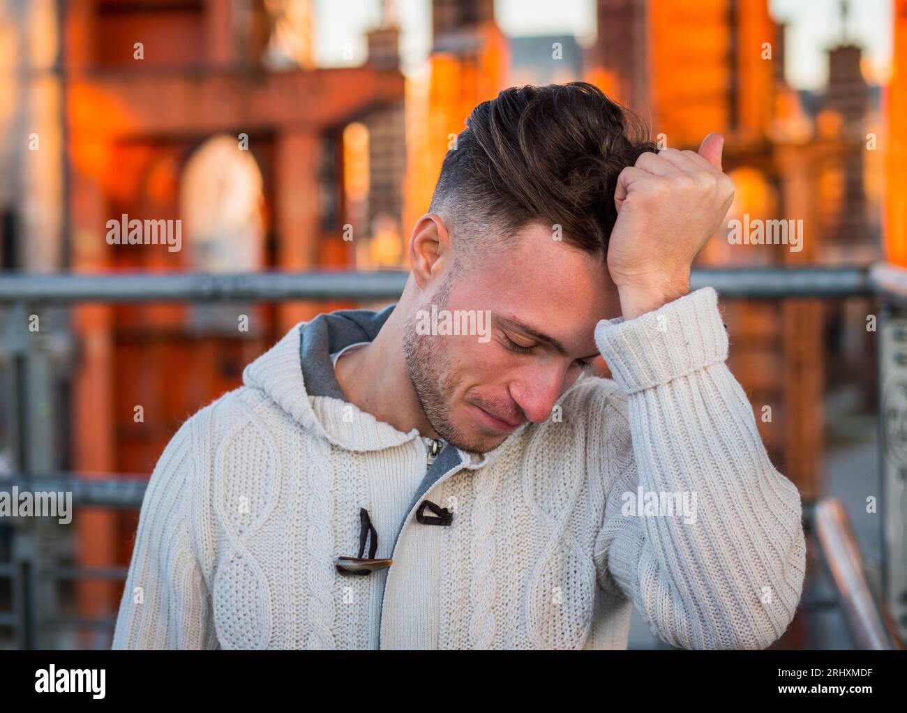 Photo of a man in distress, holding his head Stock Photo - Alamy