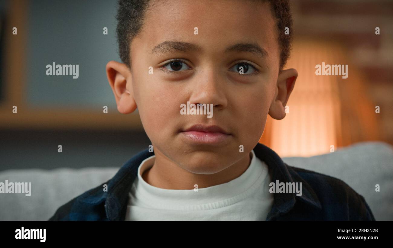 Portrait sad cute little African American boy looking down look at ...