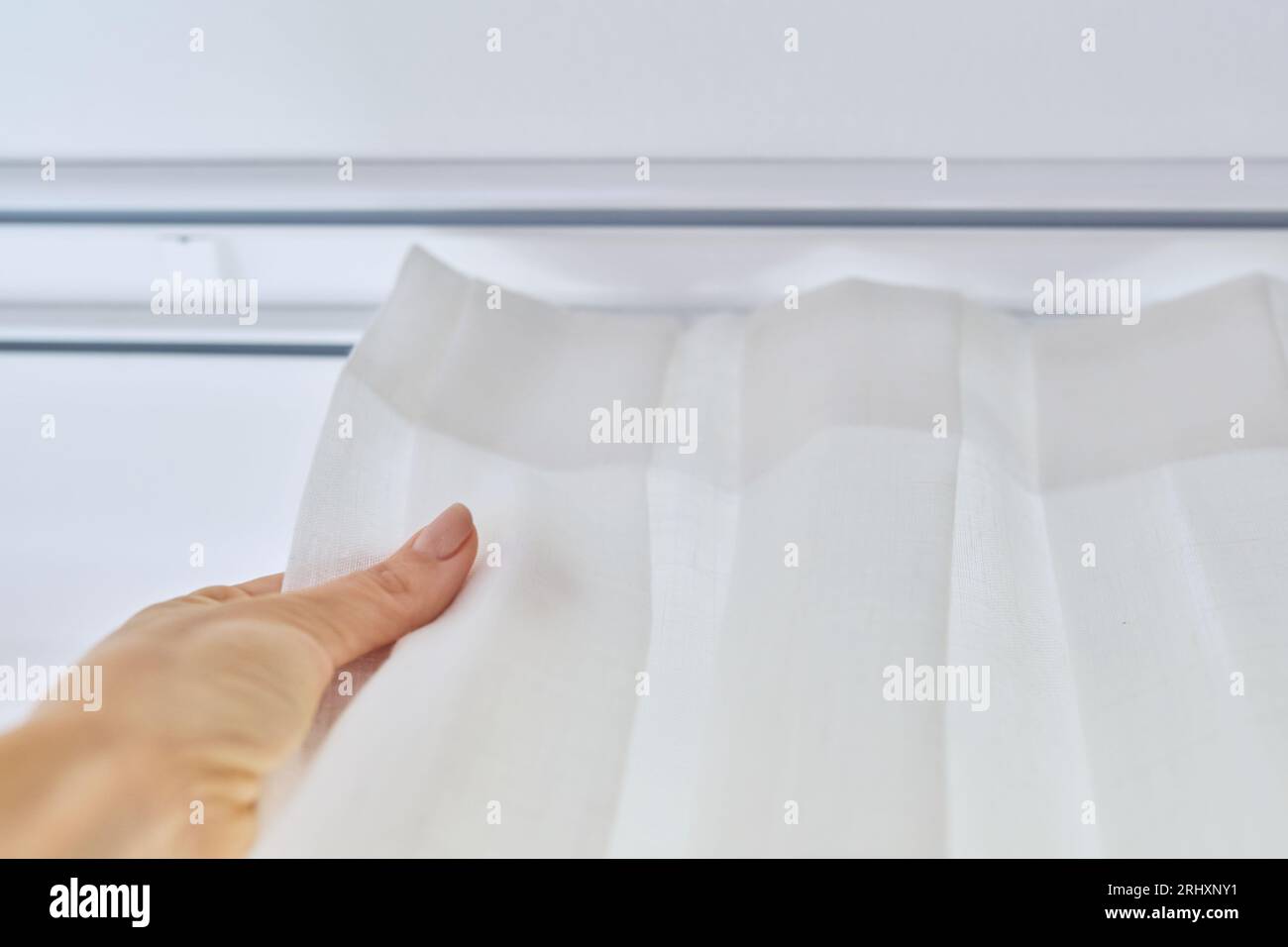 Translucent white textured curtain on window, close-up of cornice and ...