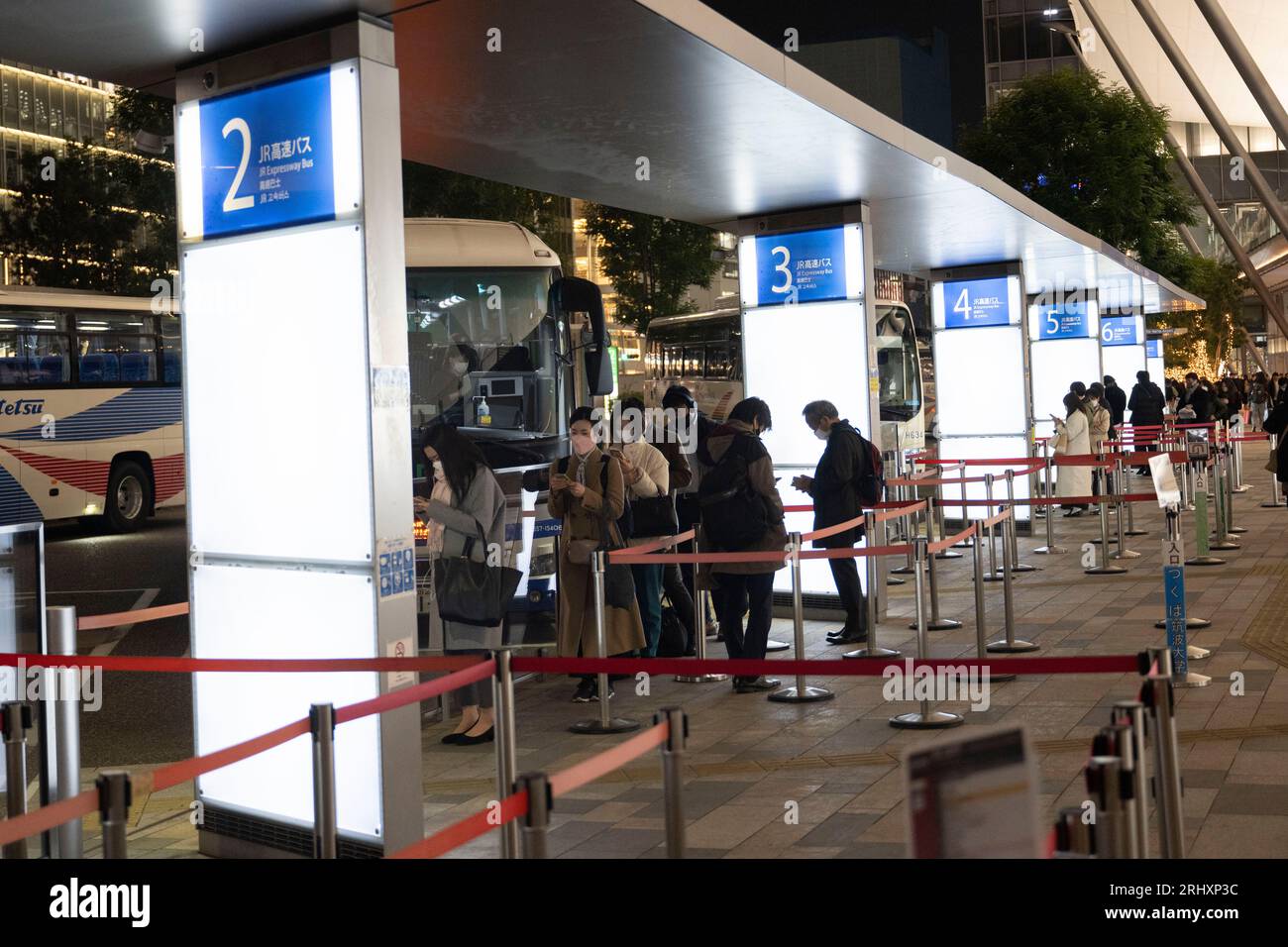 Tokyo, Japan. 11th Jan, 2023. Commuters wait to board a intercity bus ...