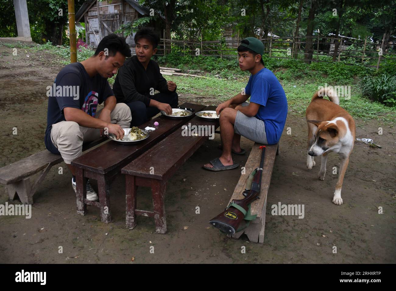 Tribal volunteers from the Kuki-Zo community eat lunch after returning ...