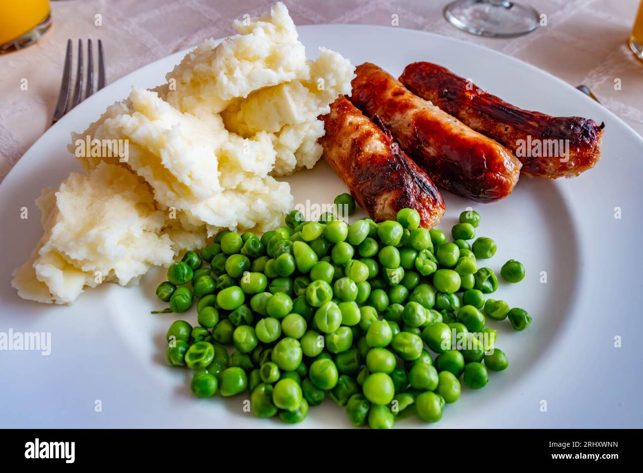 Sausages, mashed potatoes and garden peas for dinner Stock Photo - Alamy