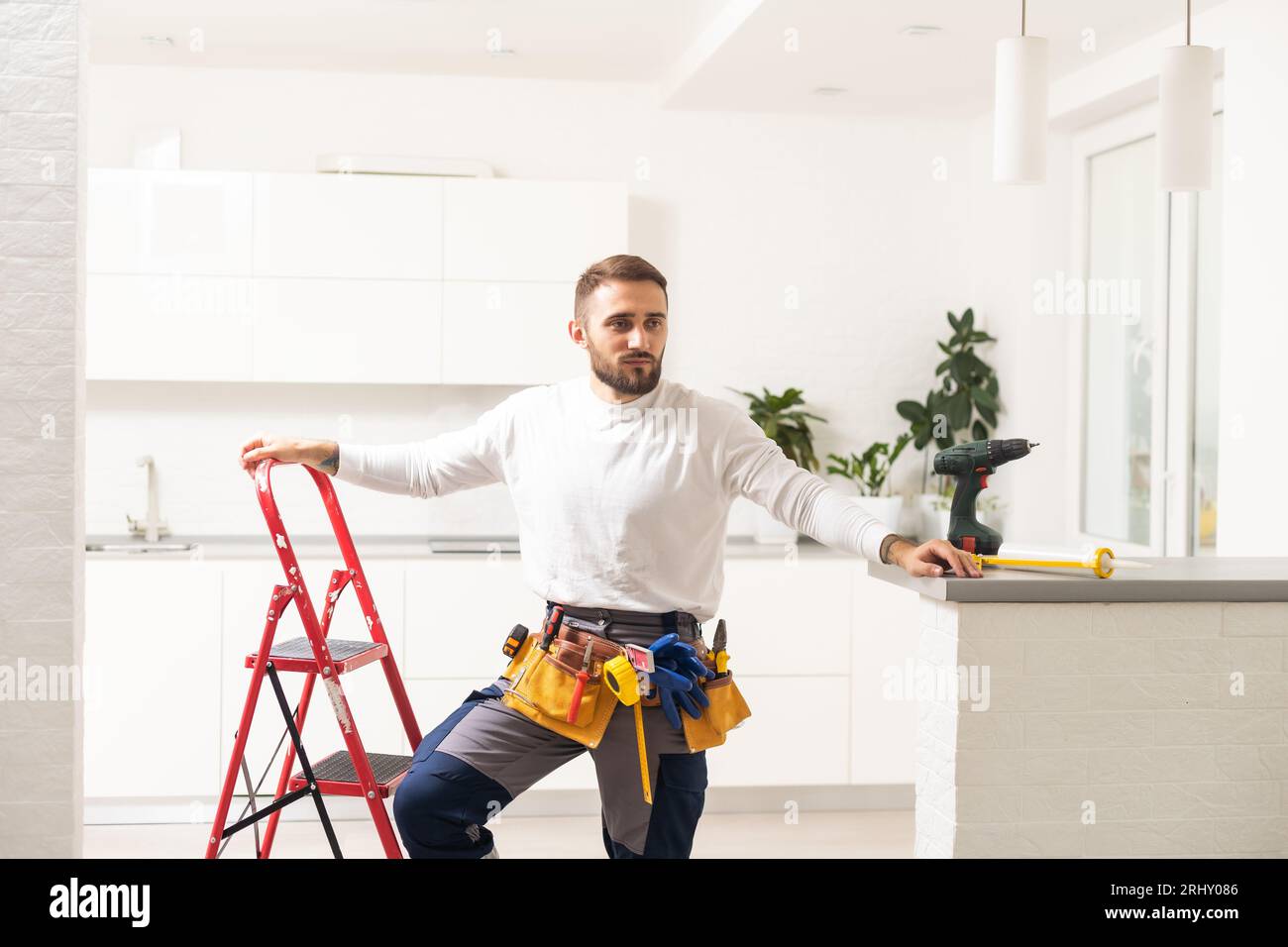 Professional worker climbing up ladder in room Stock Photo - Alamy