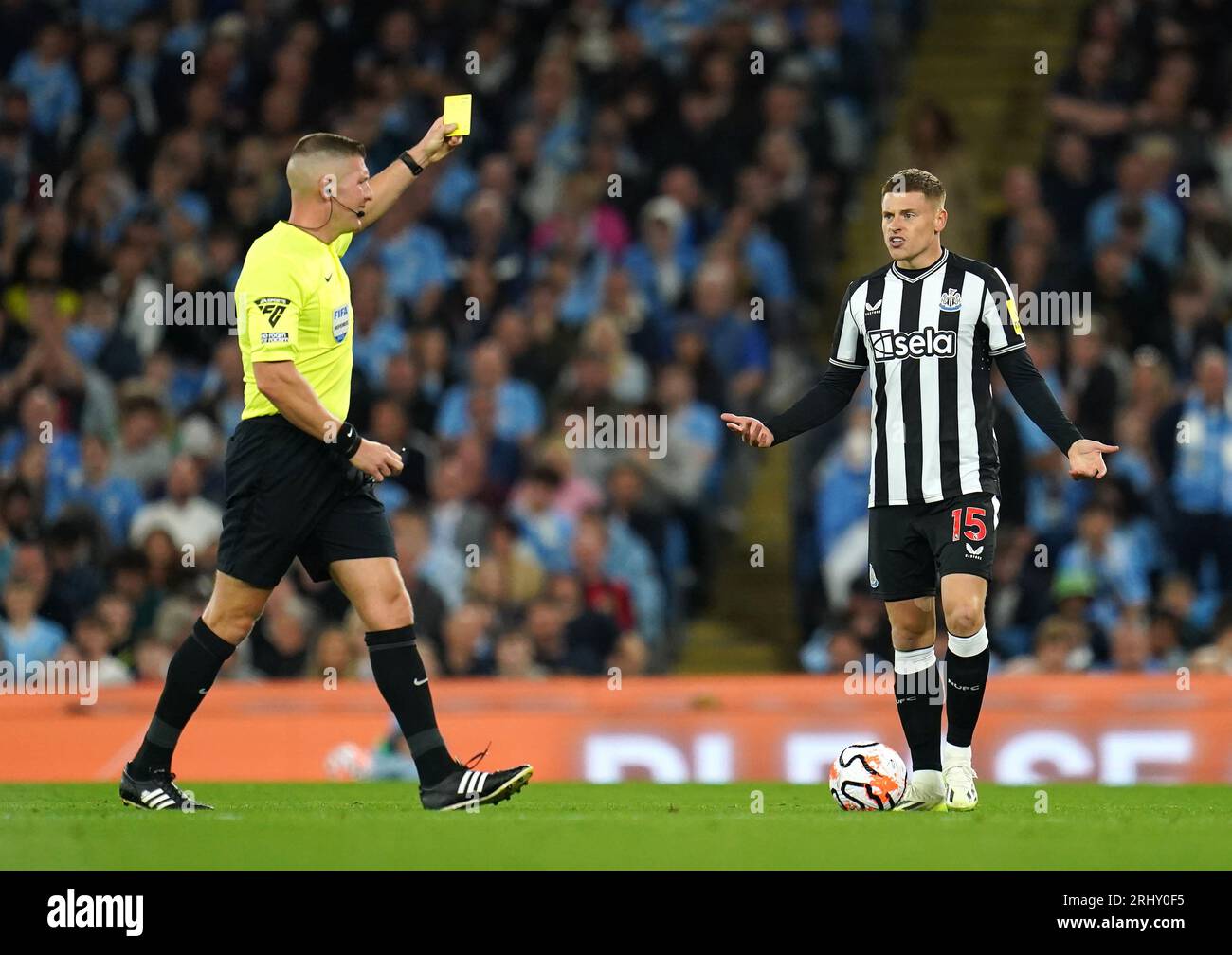 Referee Robert Jones shows a yellow card to Newcastle United's Harvey ...