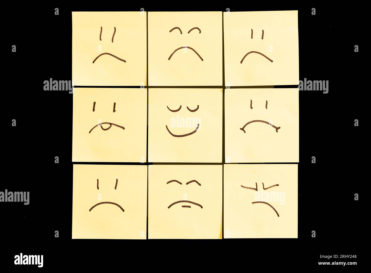 Block of nine sticky notes with sad, angry and one happy face. Concept ...
