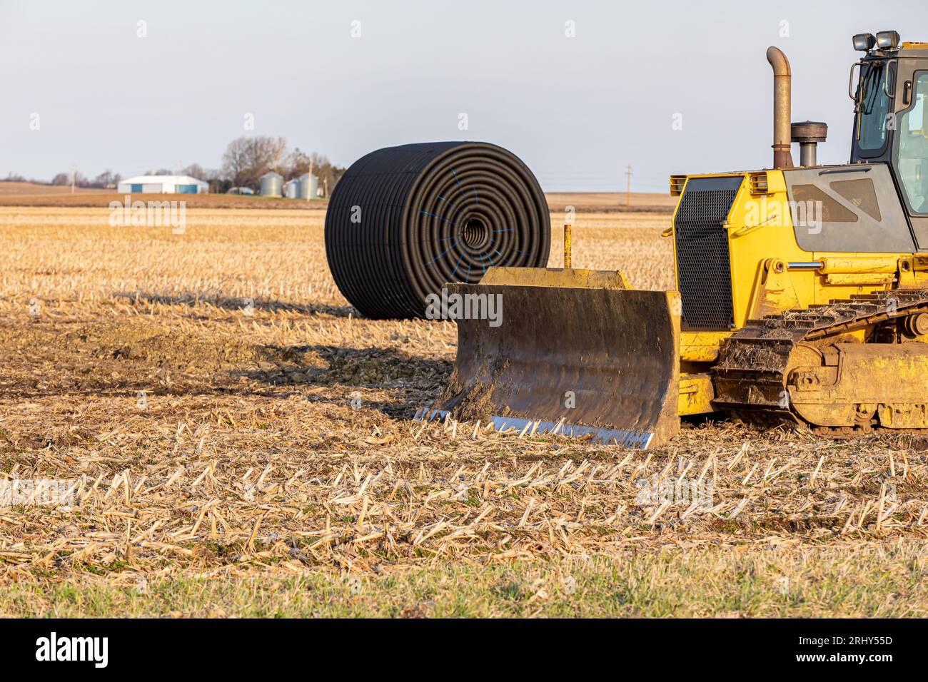 Bulldozer and field tile in farm field. Water drainage, soil ...