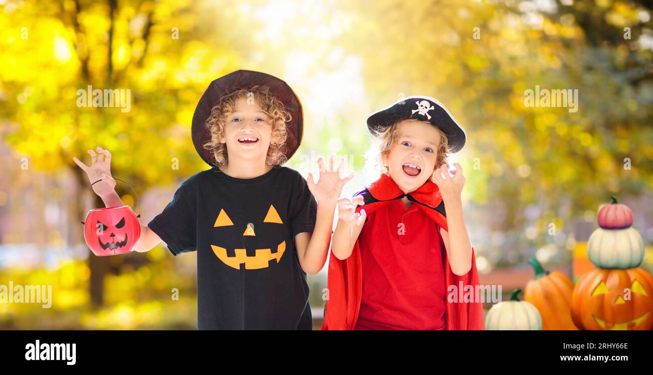 Kids trick or treat in Halloween costume. Children in colorful dress up ...