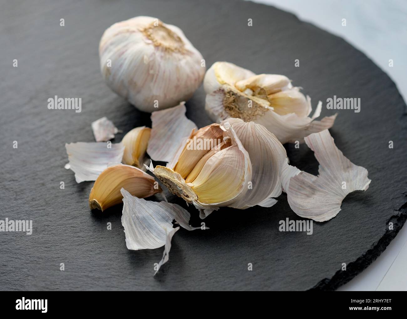 Garlic on a black background top view. Two heads of garlic, one whole ...